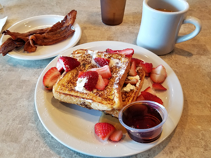 The French toast that launched a thousand return visits, adorned with fresh strawberries and a side of crispy bacon. Breakfast nirvana achieved!