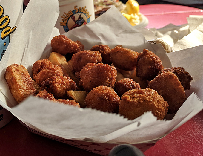 Golden-fried morsels nestled in paper &ndash; each bite delivering that perfect crunch before yielding to tender seafood within. Worth every napkin.