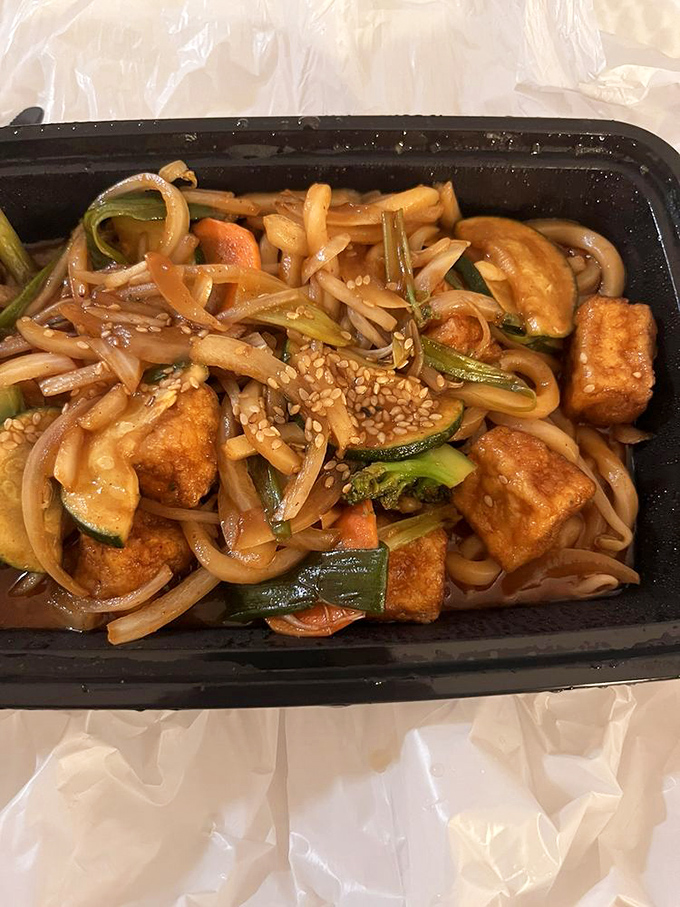 Fried yaki udon with tofu dances in a savory sauce, proving that noodles are the universal language of comfort food.