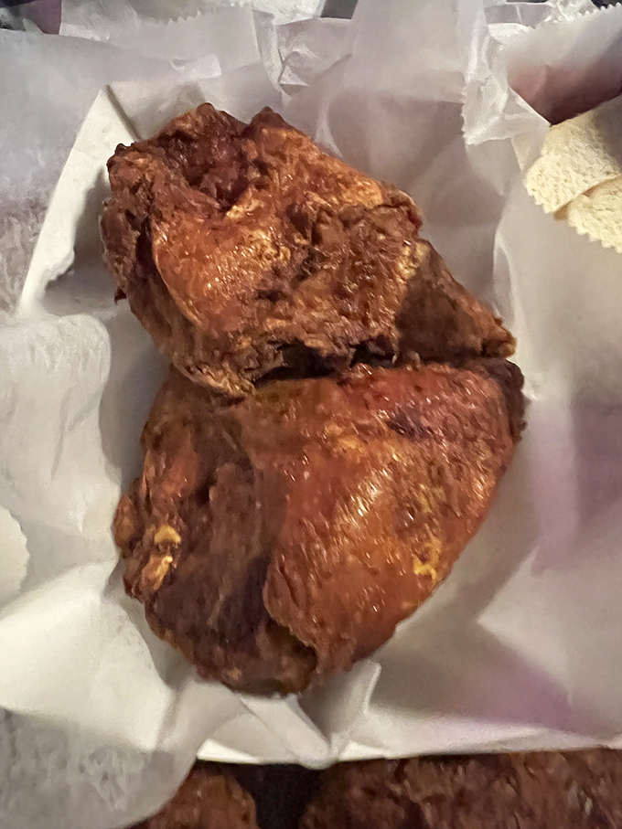 Behold, the main event – fried chicken with a crust so perfect it deserves its own Instagram account. The paper wrapping is just trying to contain the glory.