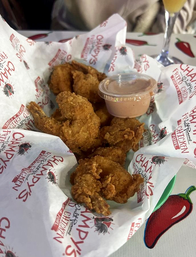 Perfectly golden fried shrimp nestled in Champy's signature paper—like little crispy treasures waiting to be dipped in that tangy sauce.