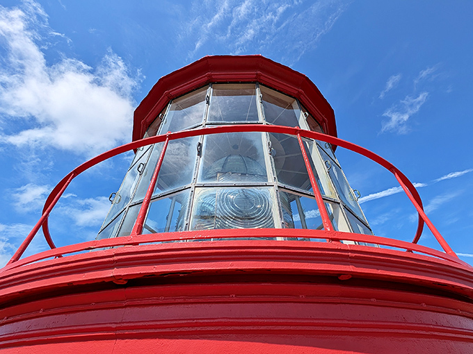 Looking up at the lantern room's glass panels and red framework feels like peering into the heart of a giant, nautical jewel box.