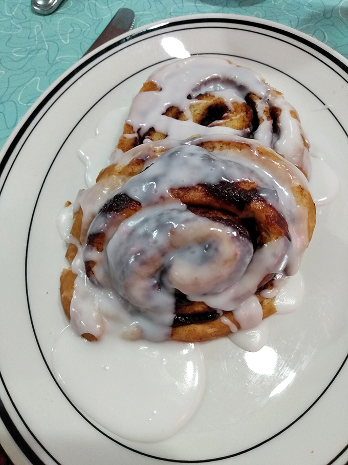 The cinnamon roll arrives like a sweet spiral galaxy on a plate, dripping with icing that's making a break for freedom. Worth every sticky finger that follows.