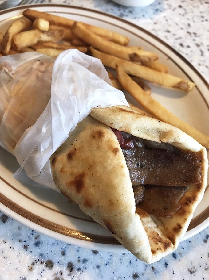Gyro perfection wrapped in pillowy pita, accompanied by golden fries. This handheld masterpiece is worth every napkin you'll need.