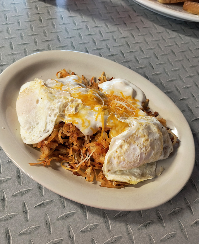 This isn't just breakfast &ndash; it's edible architecture. Crispy hash browns supporting two sunny eggs like a foundation holding up the morning's possibilities.