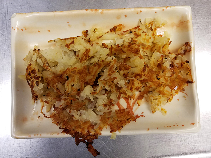 These hash browns have achieved the golden-brown perfection that home cooks dream about &ndash; crispy, buttery potato magic on a humble plate.