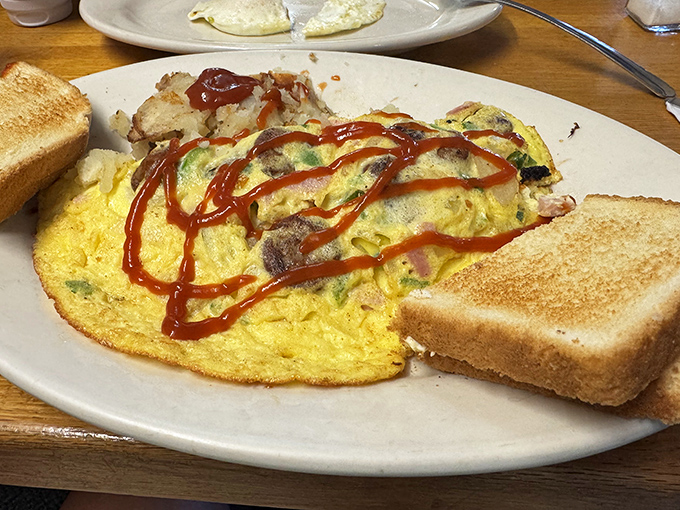 This isn't just an omelet&mdash;it's a morning masterpiece with a supporting cast of crispy potatoes and toast standing by to soak up every delicious bite.