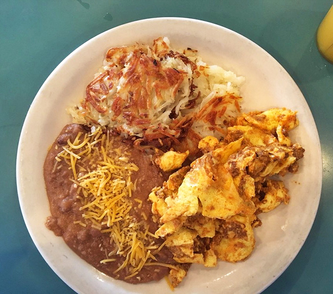 A plate that tells a story of comfort&mdash;refried beans with melty cheese, crispy hash browns, and scrambled eggs that look like they were made with actual care.