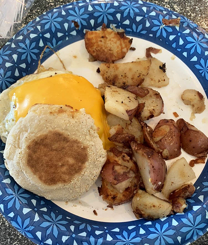 A perfect breakfast trinity: golden English muffin, sunshine-yellow cheese, and home fries crisped to the exact point between tender and crunchy.