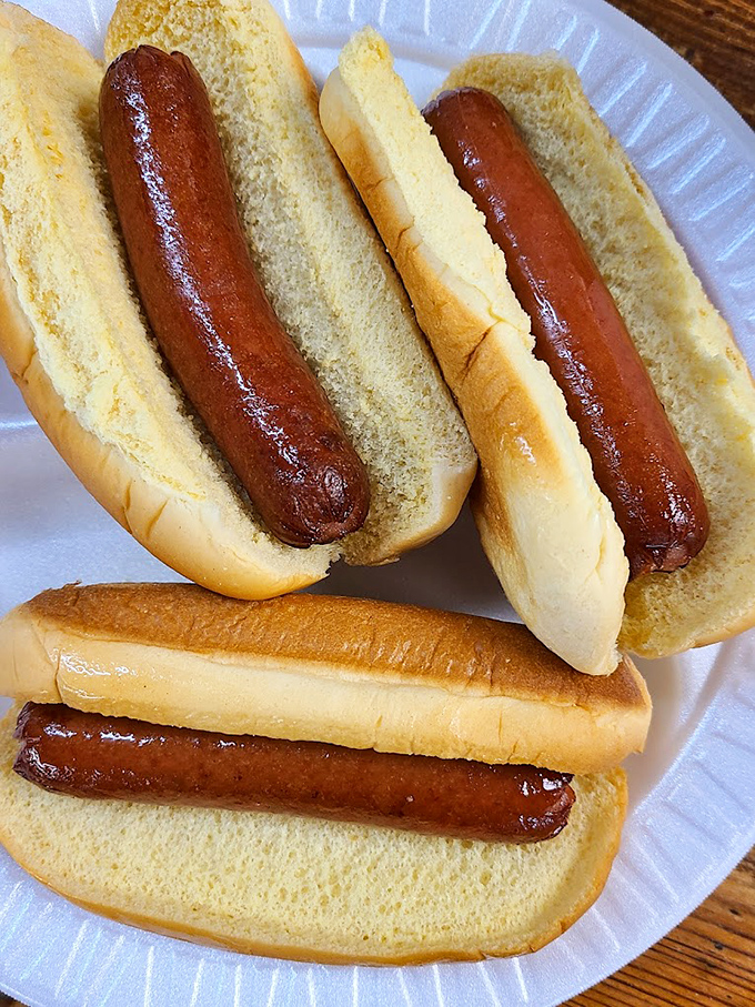 Hot dogs so perfectly nestled in their buns, they look like they're taking a delicious nap before their inevitable fate.