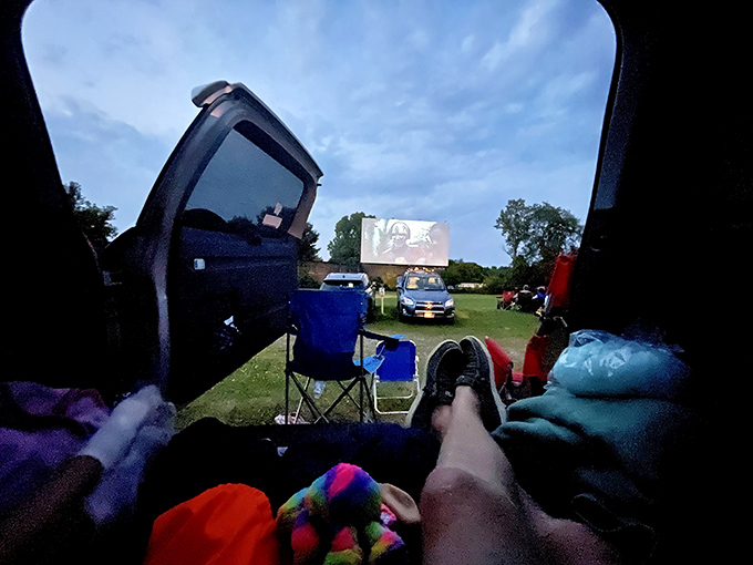 The roadside marquee promises entertainment under the stars. Cars queue up for that perfect combination of movies, snacks, and Wisconsin summer nights.