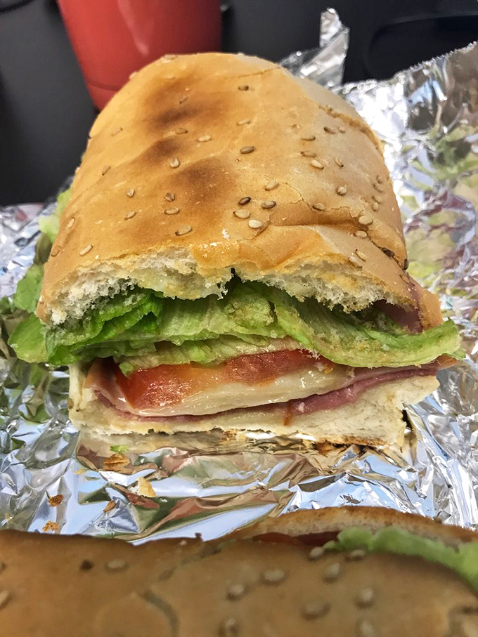 This isn't just a sandwich; it's an architectural marvel with layers that would make a geological survey team jealous. The lettuce provides that crucial crunch factor.