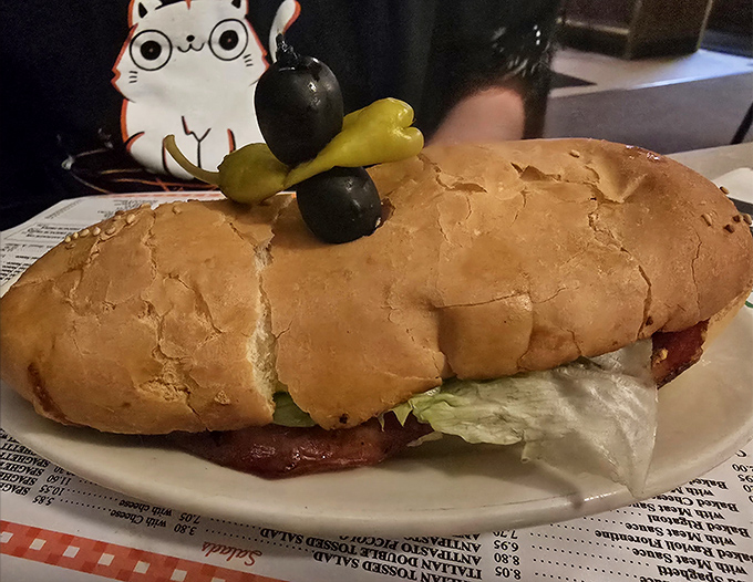 Luigi's Italian sub is architectural perfection&mdash;crusty bread cradling layers of meat, cheese, and veggies, topped with olives standing guard like tiny sentinels of flavor.