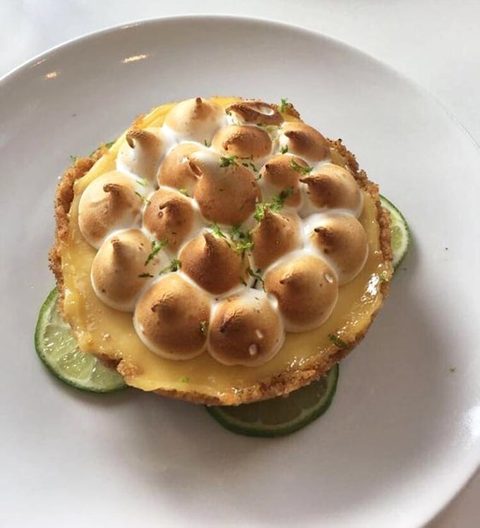 Key lime pie reimagined as edible art. That toasted meringue crown atop tangy custard is what dessert dreams are made of.