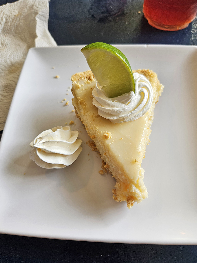 Key lime pie that strikes the perfect balance between tart and sweet, topped with a dollop of whipped cream and that essential lime wedge.