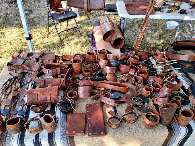 Leather goods with character spread across a weathered blanket. Each belt, holster, and cuff carries the rich amber patina that only comes from genuine craftsmanship.