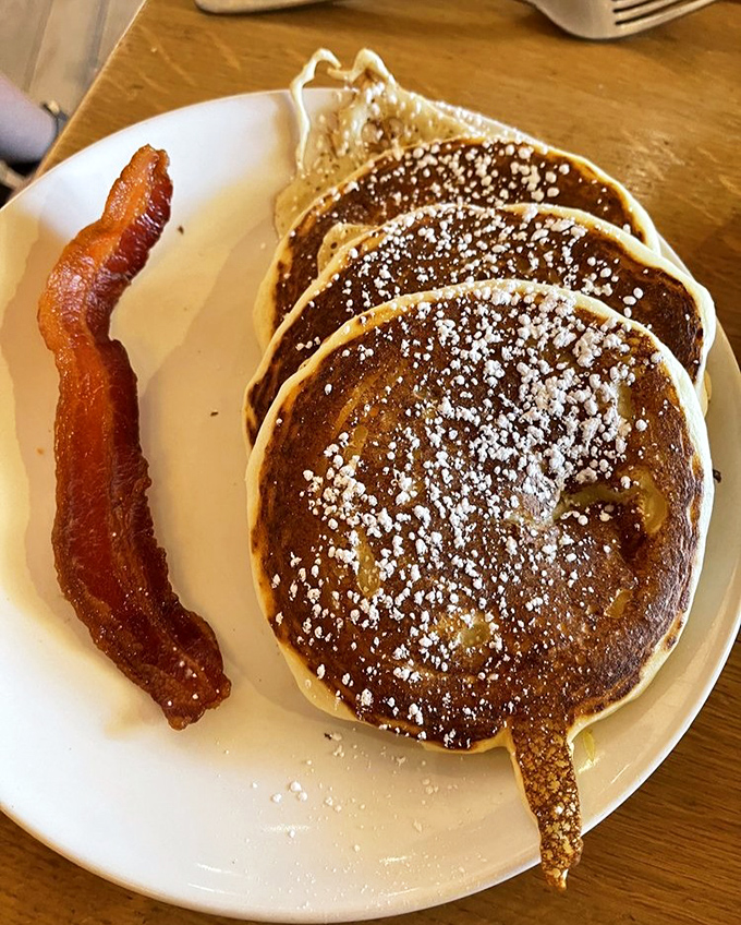 Lemon ricotta pancakes and bacon: breakfast's perfect power couple. These fluffy discs of joy, dusted with powdered sugar, might even make your cardiologist consider an exception.