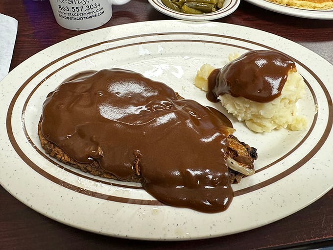Liver and onions smothered in rich gravy with a side of mashed potatoes&mdash;a dish that separates casual diners from true comfort food connoisseurs.