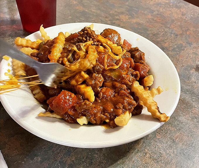 Chili cheese fries that laugh in the face of utensils&mdash;a glorious mess that transforms a side dish into the main event worth every napkin.