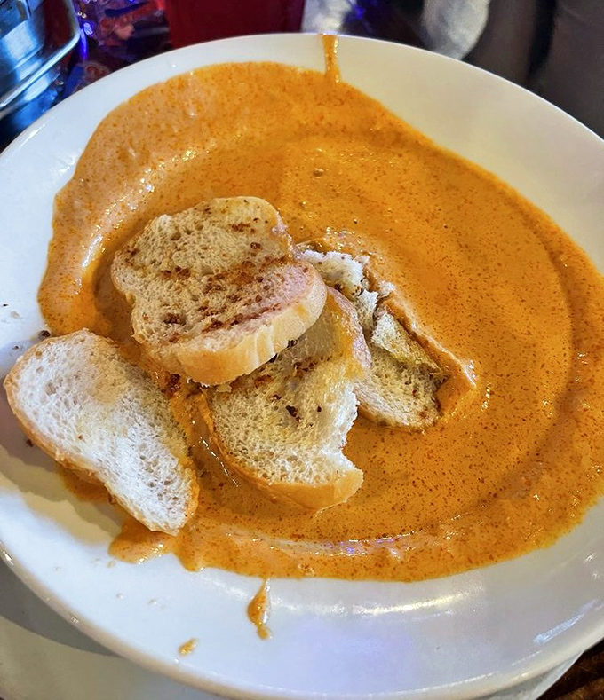 This lobster bisque isn't just soup; it's a warm Gulf hug in a bowl, with toasted bread islands waiting to be dunked into creamy coral seas.