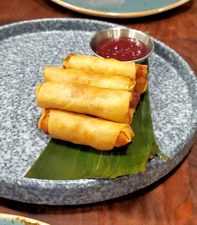 Golden lumpia rolls arrive like edible cigars, each one packed with more satisfaction than a Vegas jackpot.
