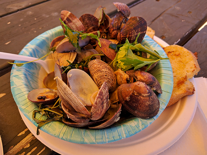 Manila clams swimming in their final bath of white wine and herbs. Proof that simplicity, when done right, is the ultimate luxury.