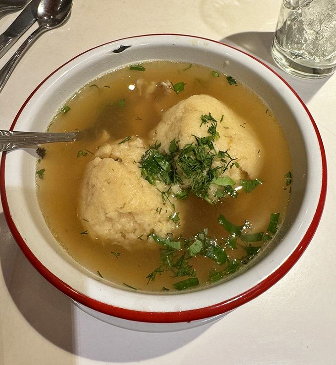 Golden matzo balls float like delicious planets in a universe of clear, aromatic broth. Chicken soup for more than just the soul.