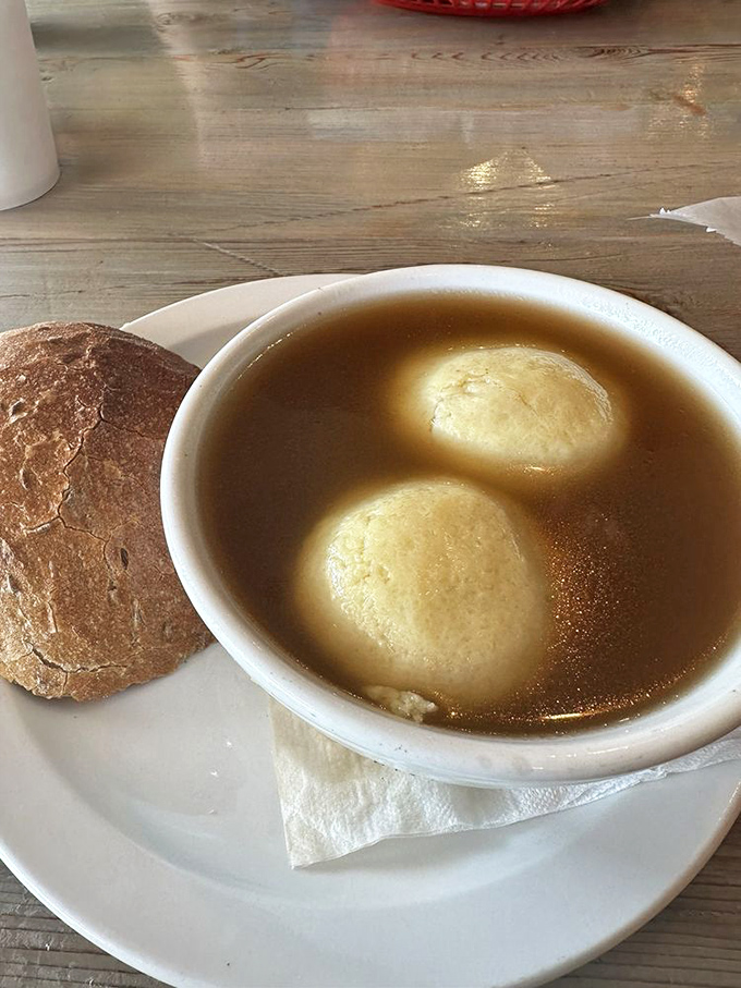Two perfect matzo balls floating in golden broth &ndash; like delicious dumplings from the comfort food cosmos.