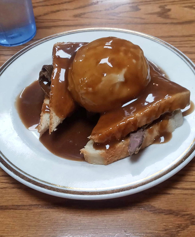 Hot roast beef sandwich swimming in gravy with a perfect scoop of mashed potatoes. Comfort food that hugs you from the inside out.