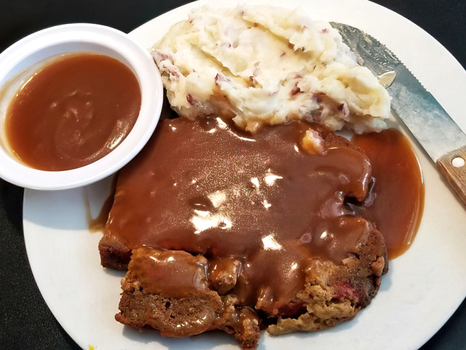 Meatloaf swimming in gravy so rich it could buy a yacht, alongside mashed potatoes that clearly never met a powder.