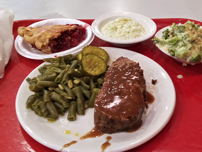 Meatloaf dinner with all the fixings, including what appears to be cherry pie for dessert. This tray isn't a meal; it's a hug on a plate.