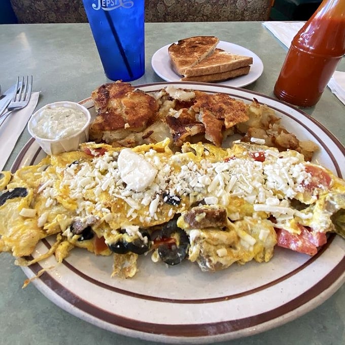 This isn't just an omelet&mdash;it's a Mediterranean vacation folded into eggs. Feta cheese melts into a landscape of vegetables while crispy potatoes stand by as worthy companions.