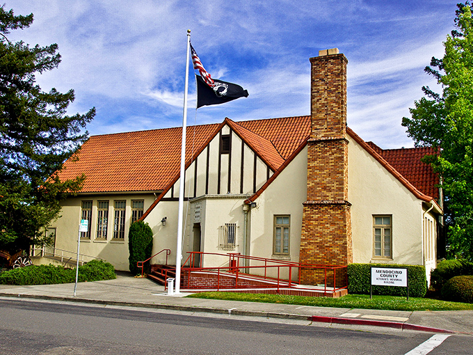 The Mendocino County Veterans Memorial Building combines Tudor-inspired design with civic purpose, flying the American flag proudly against a perfectly blue California sky.