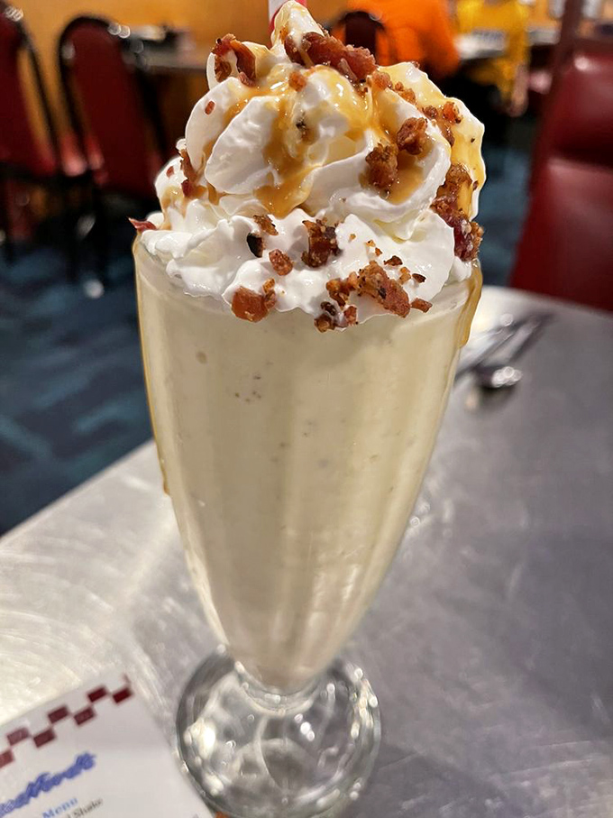 This isn't just a milkshake&mdash;it's a structural engineering marvel topped with whipped cream, caramel, and what appears to be bacon bits. Genius!