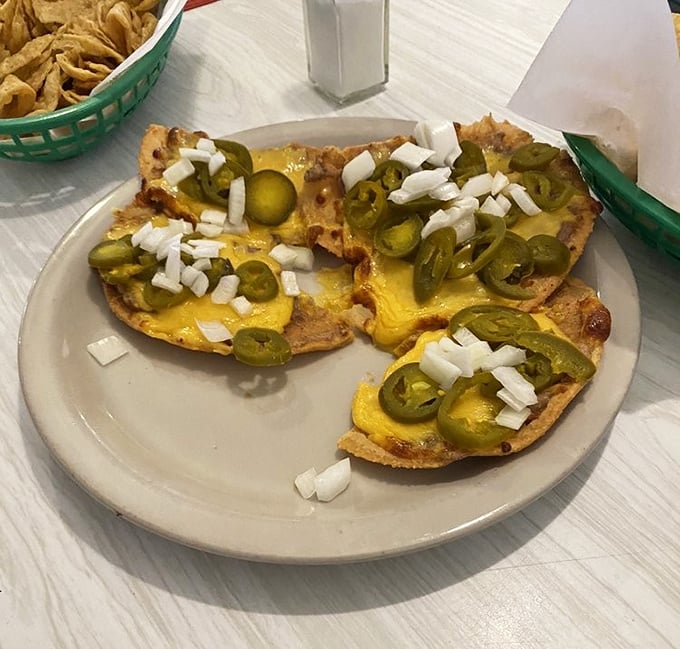 Nachos that respect the fundamentals: homemade chips, melted cheese, jalape&ntilde;os, and diced onions. No architectural showboating, just pure satisfaction.
