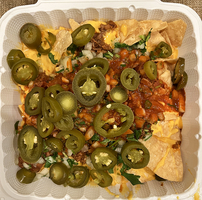 Nachos that laugh in the face of stadium versions—loaded with jalapeños, cheese, and enough toppings to require a structural engineering degree.