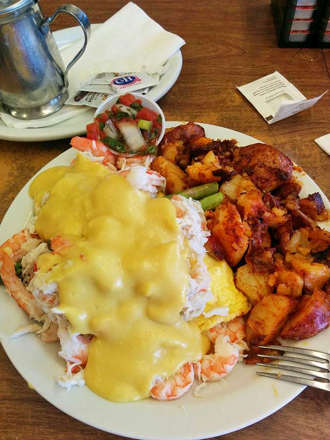 This isn't just breakfast, it's a seafood celebration &ndash; crab and eggs performing a sunrise ballet beneath a golden hollandaise waterfall.