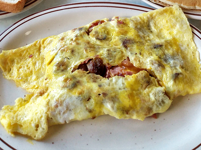 This isn't just an omelet&mdash;it's a masterclass in breakfast architecture. Perfectly folded eggs housing a treasure trove of ham and cheese. Morning magic on a plate.
