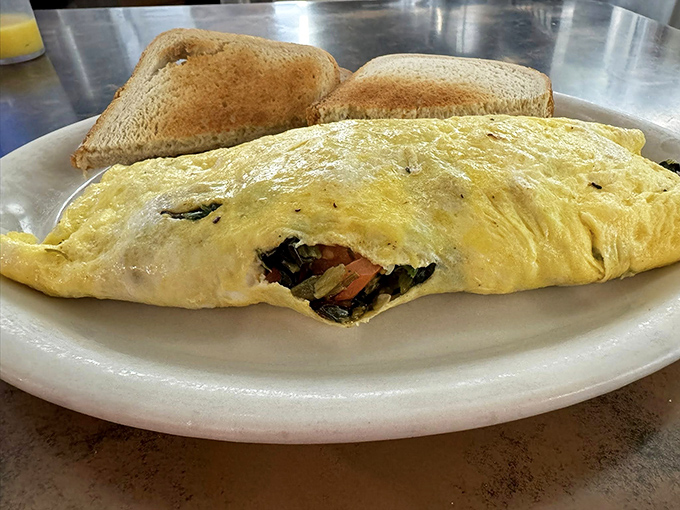 An omelet that's practically bursting at the seams, flanked by toast soldiers ready for the breakfast battlefield.