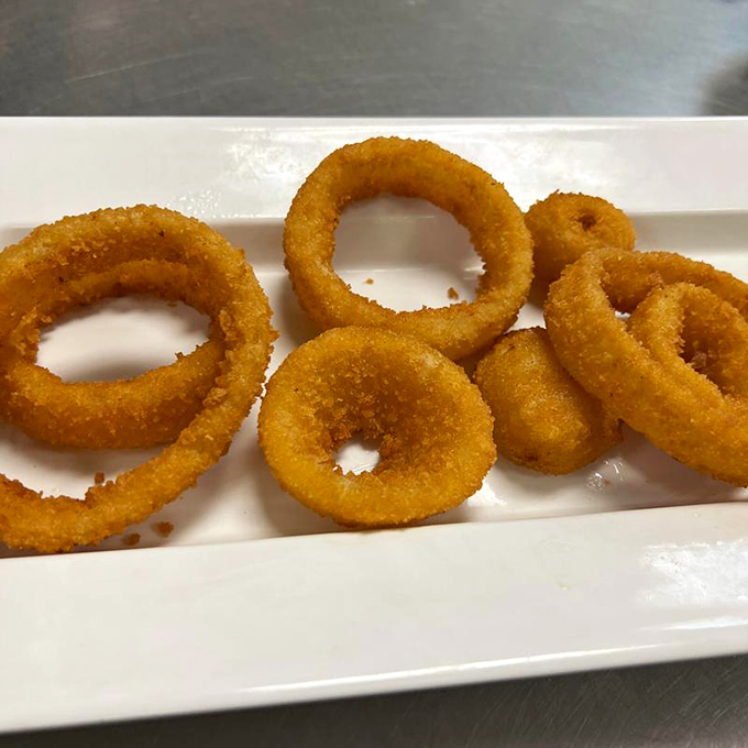 Golden, crispy onion rings that shatter with each bite – the perfect sidekick to Tampa's cheesesteak champion.