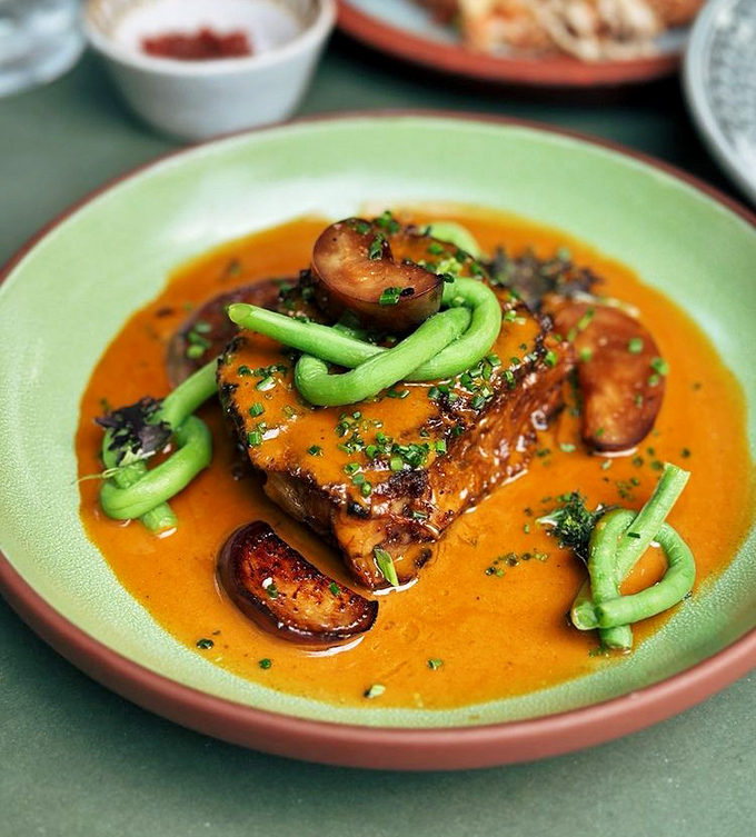 "The Oxtail Kare Kare swims in a sauce so rich and velvety, you'll be plotting ways to take a bath in it. Those green beans are just showing off."