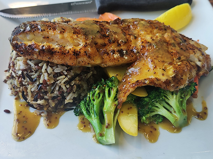 This isn't just grilled fish &ndash; it's pan-seared rockfish performing a delicate balancing act atop wild rice and vegetables, all dressed in a sauce that deserves its own fan club.