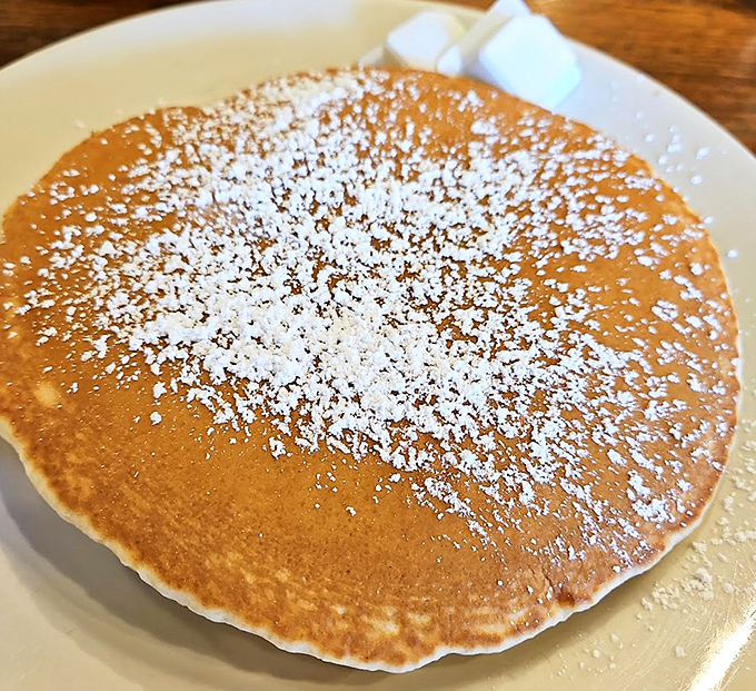 A pancake dusted with powdered sugar like the first perfect snowfall of winter. Simple pleasures are often the most profound.