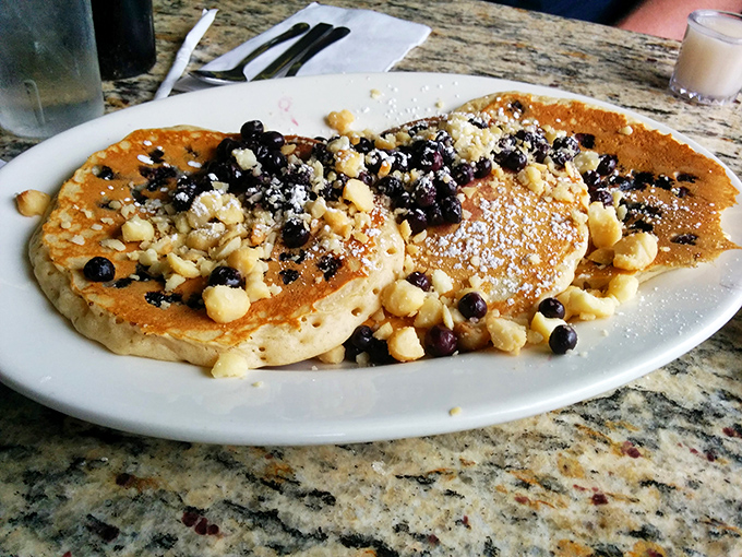 These pancakes don't just come with berries—they're a canvas for nature's candy, topped with a snowfall of powdered sugar and pure joy.