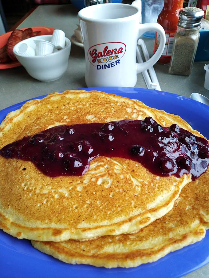 Golden pancakes wearing berry compote like a royal robe. The perfect canvas for maple syrup's sweet embrace.