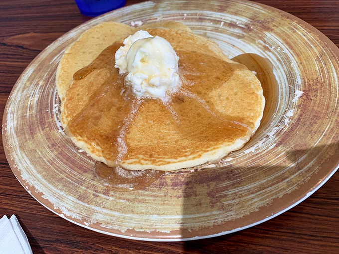 Golden pancake perfection with melting butter creating its own little maple syrup swimming pool&mdash;breakfast architecture at its finest.