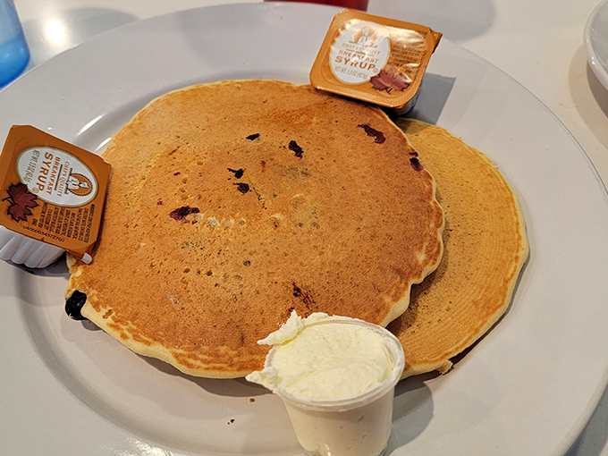 Pancakes so perfectly golden they belong in Fort Knox, with butter melting like a summer sunset and maple syrup standing by.