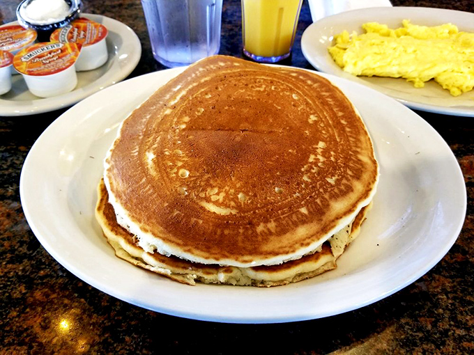 Pancake perfection doesn't need to whisper&mdash;it speaks for itself. Golden, fluffy discs ready for their maple syrup baptism alongside eggs for the complete breakfast experience.