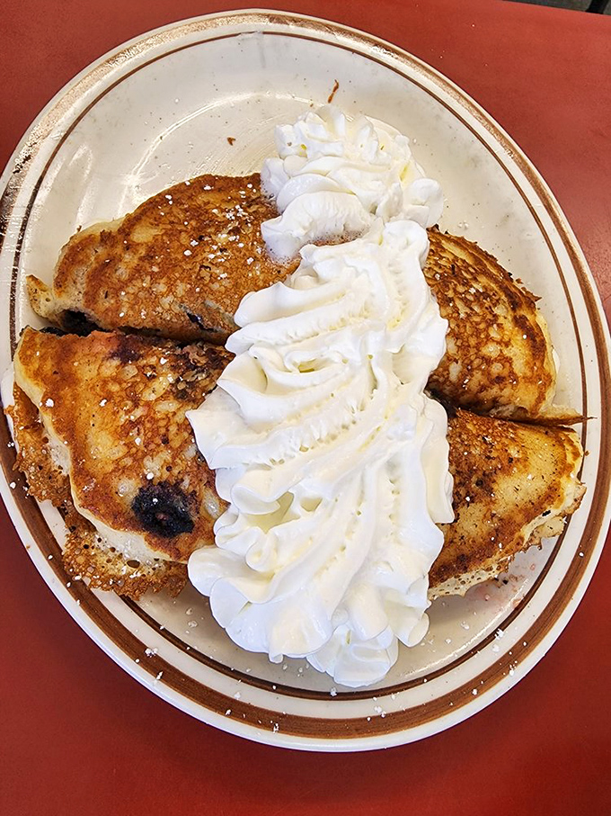 Blueberry pancakes crowned with a cloud of whipped cream&mdash;proof that sometimes the best things in life come stacked and ready for syrup.