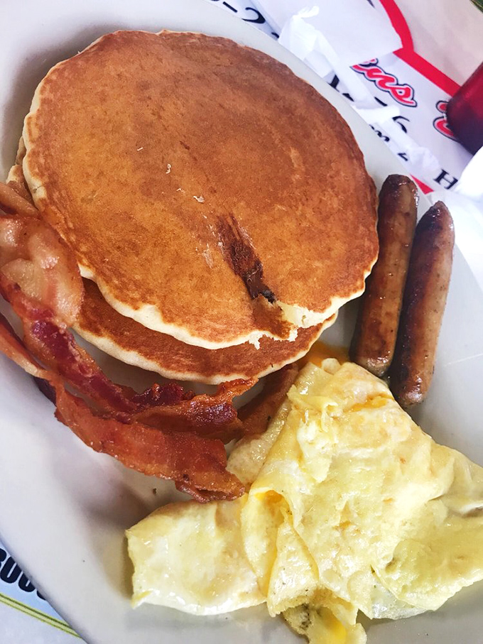 Pancakes stacked higher than your weekend expectations, with bacon that's achieved that mythical balance between crispy and chewy.
